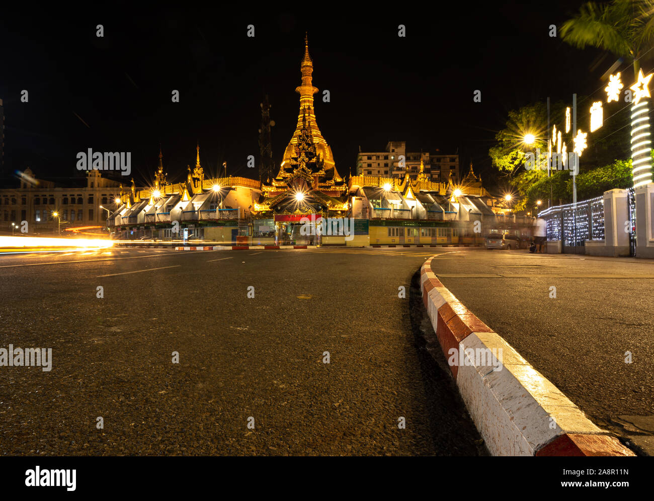 Night time and streaks of car lights in the heart of downtown Yangon ...
