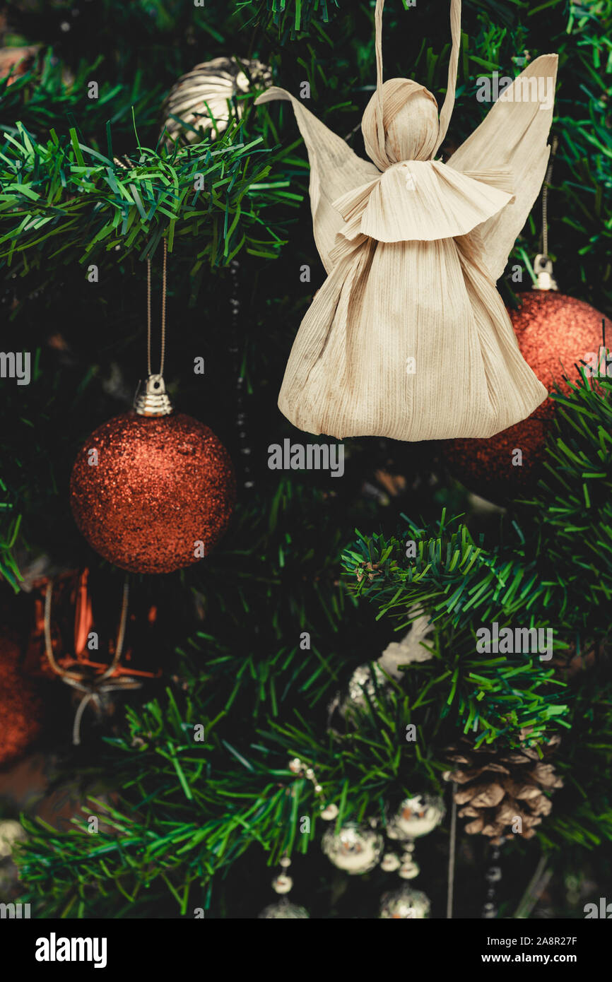 Corn husk doll on christmas tree. Red and silver christmas balls ...