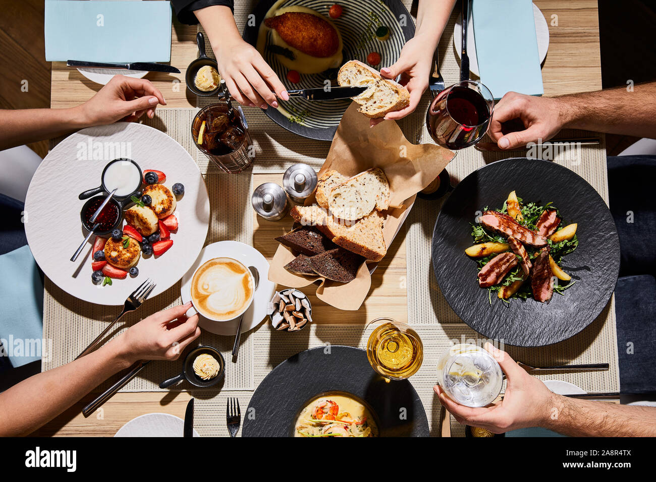 top view of people eating delicious food during dinner in restaurant ...
