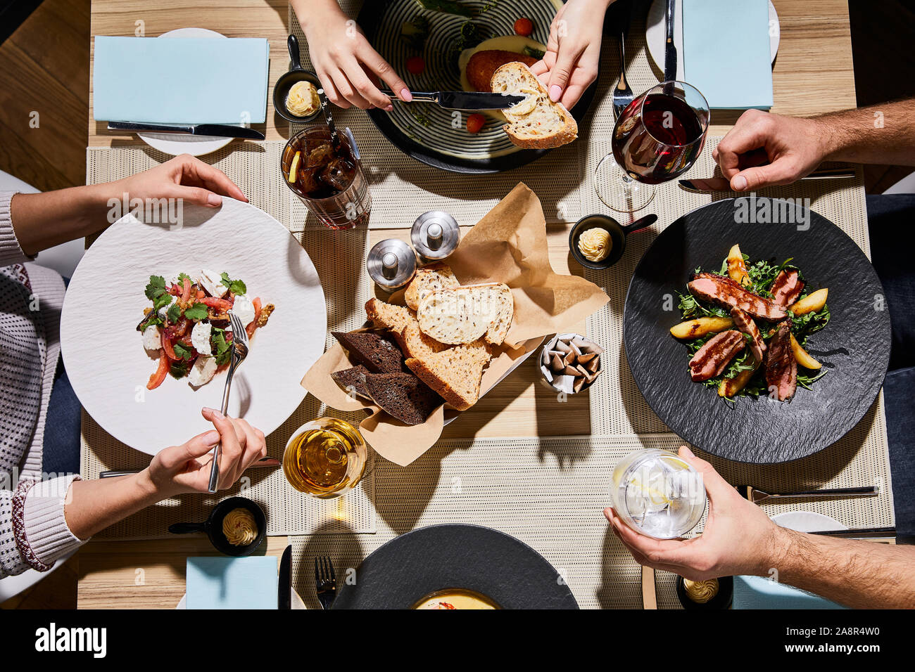 top view of people eating delicious food during dinner in restaurant ...