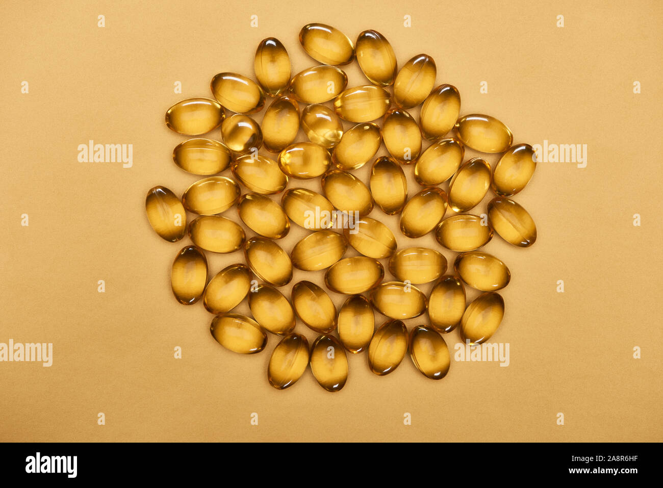 top view of golden shiny fish oil capsules on yellow background Stock ...