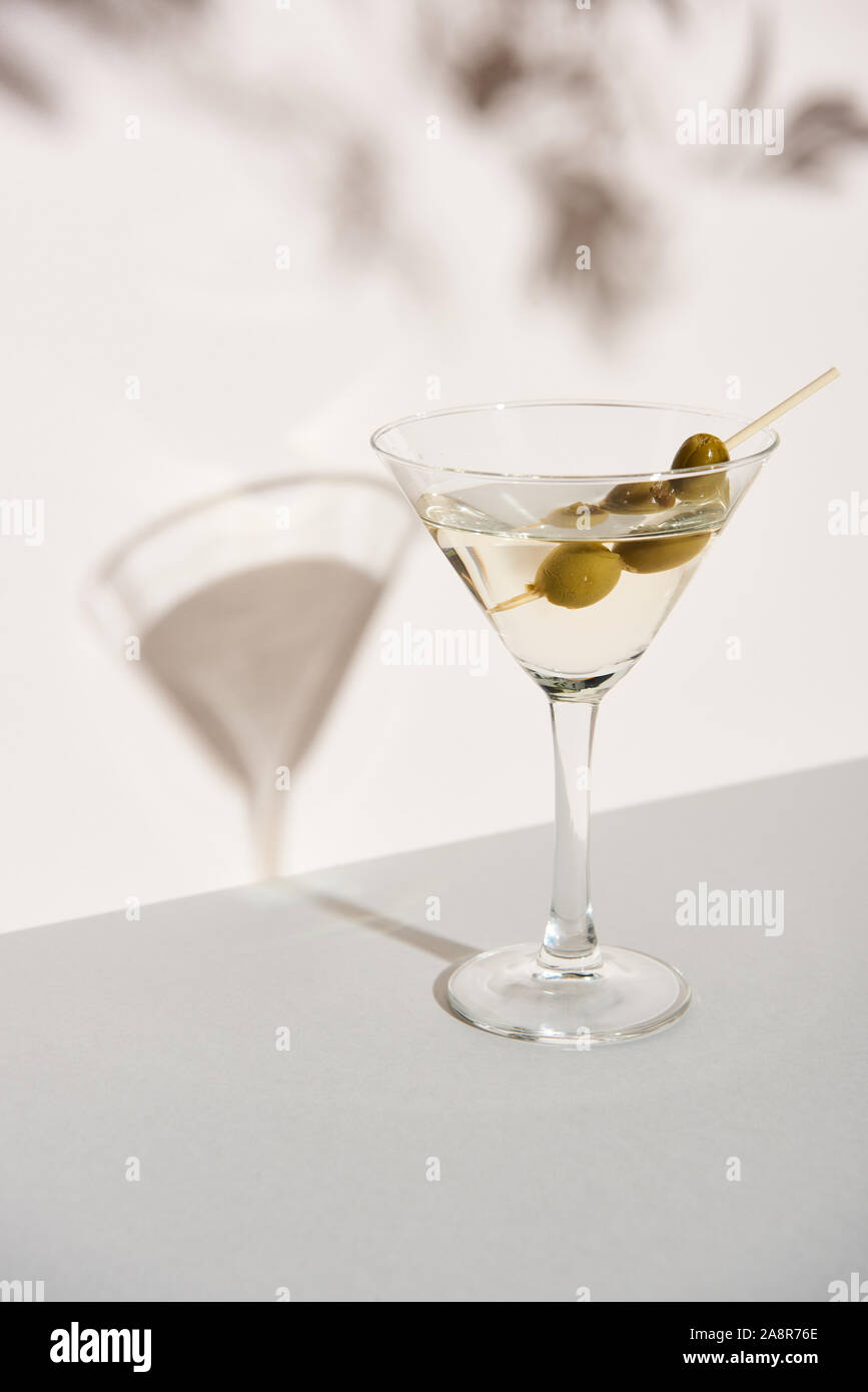 Martini with olives on white background with shadow Stock Photo - Alamy