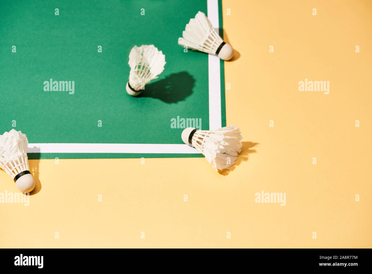 Badminton shuttlecocks on green court and yellow surface Stock Photo ...