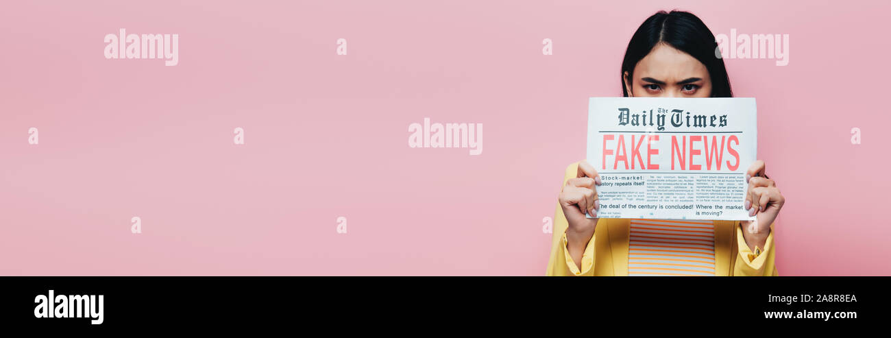 sad asian woman in yellow outfit holding newspaper with fake news ...