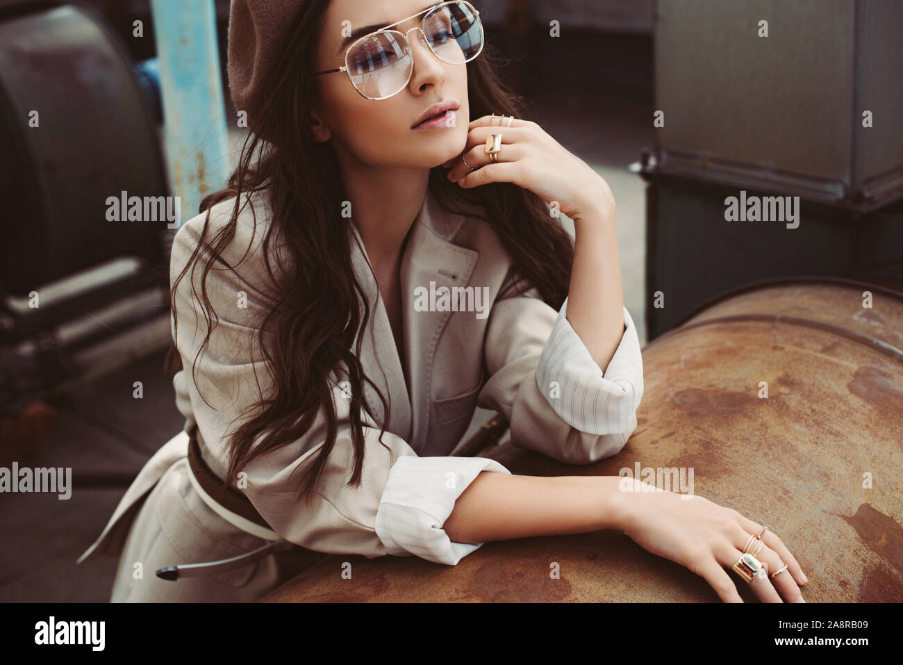 beautiful stylish model posing in beige suit and beret on urban roof ...