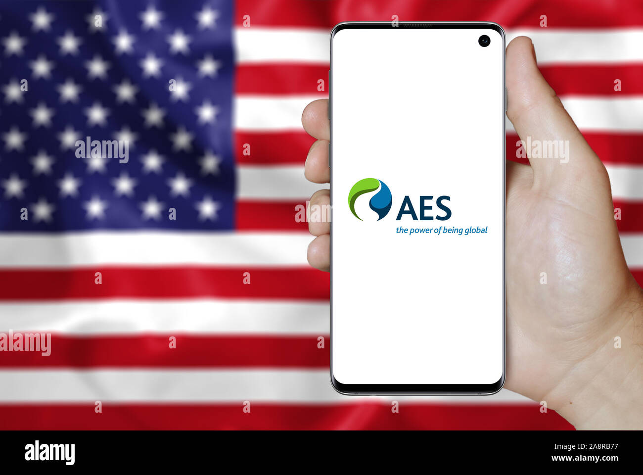 Logo of public company AES Corp displayed on a smartphone. Flag of USA ...