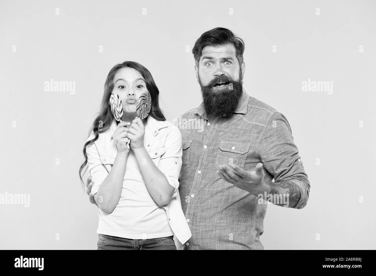 Sharing sweets with dearest people. Girl child and dad hold colorful ...