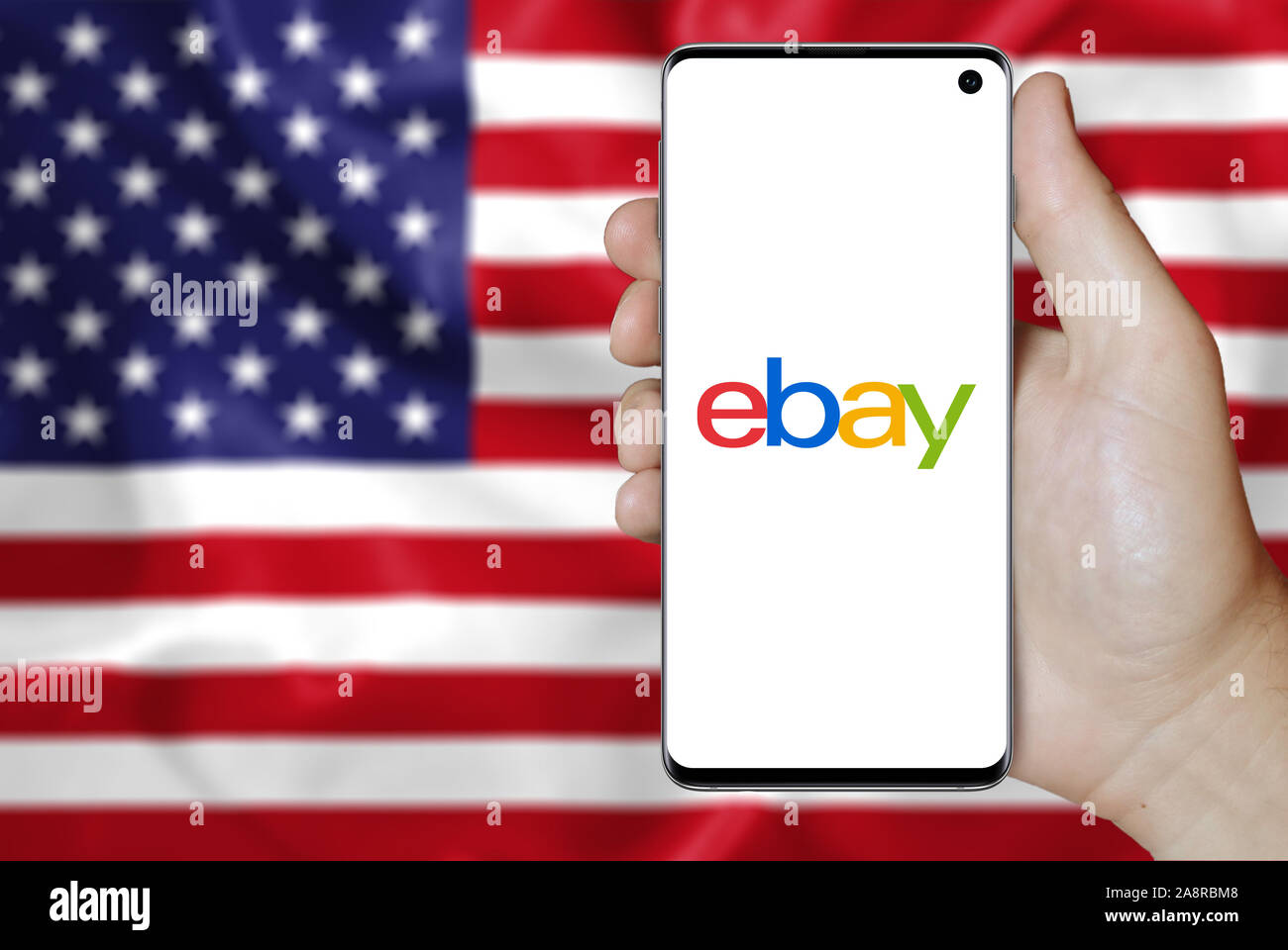 Logo of public company eBay Inc. displayed on a smartphone. Flag of USA ...