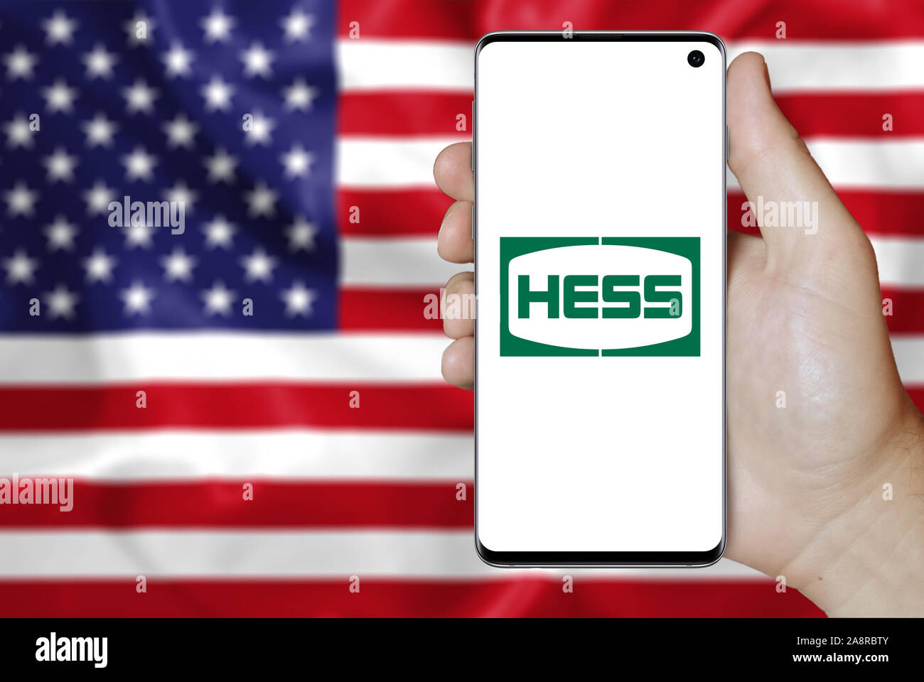 Logo of public company Hess Corporation displayed on a smartphone. Flag ...