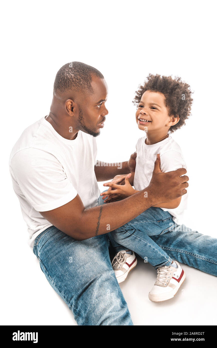 handsome african american man talking to smiling son on white ...