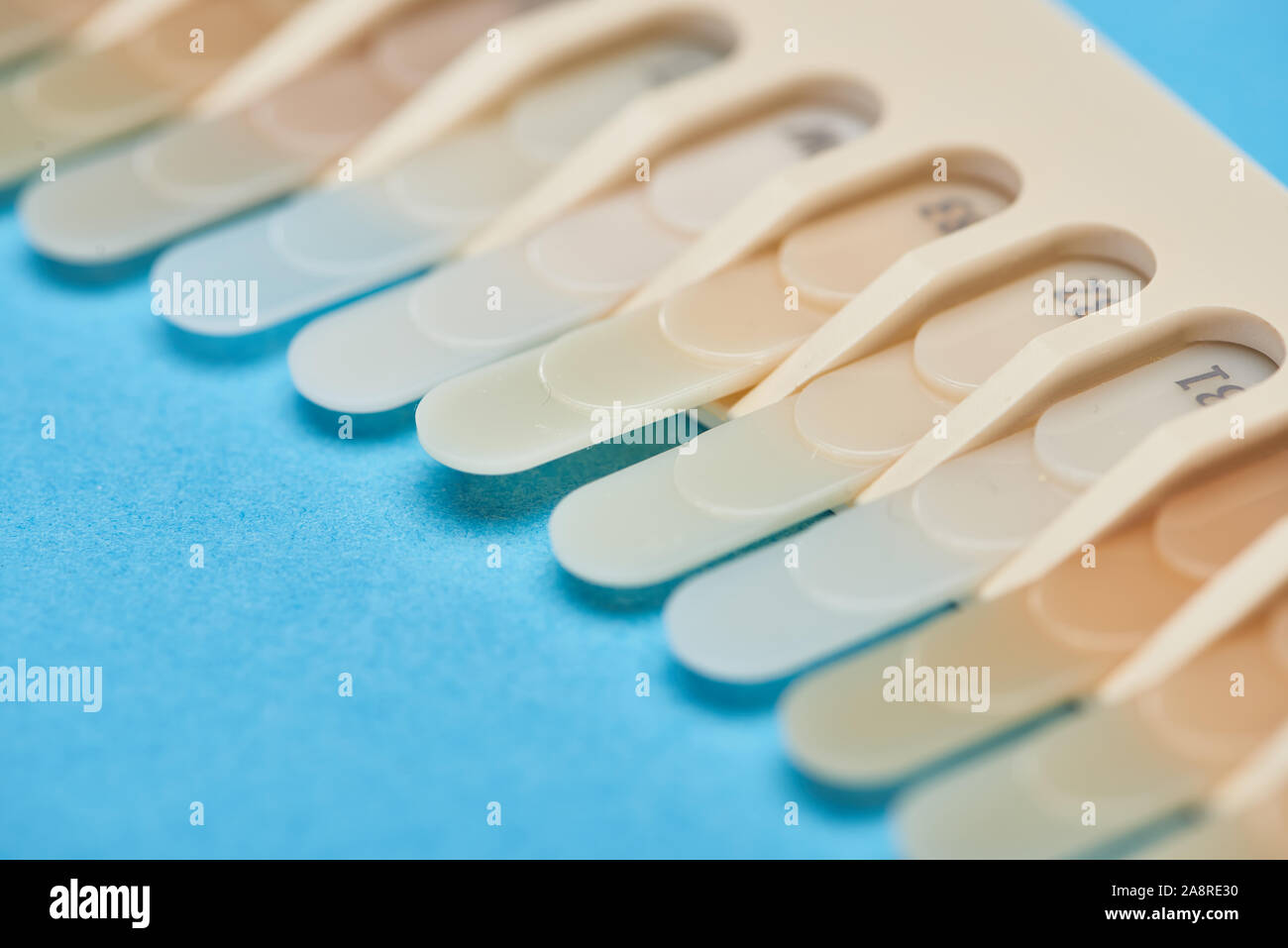selective focus of teeth palette with different shades on blue Stock ...