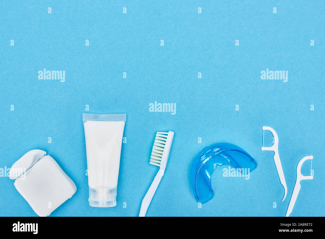 top view of toothpaste, toothbrush and teeth floss near retainer and ...