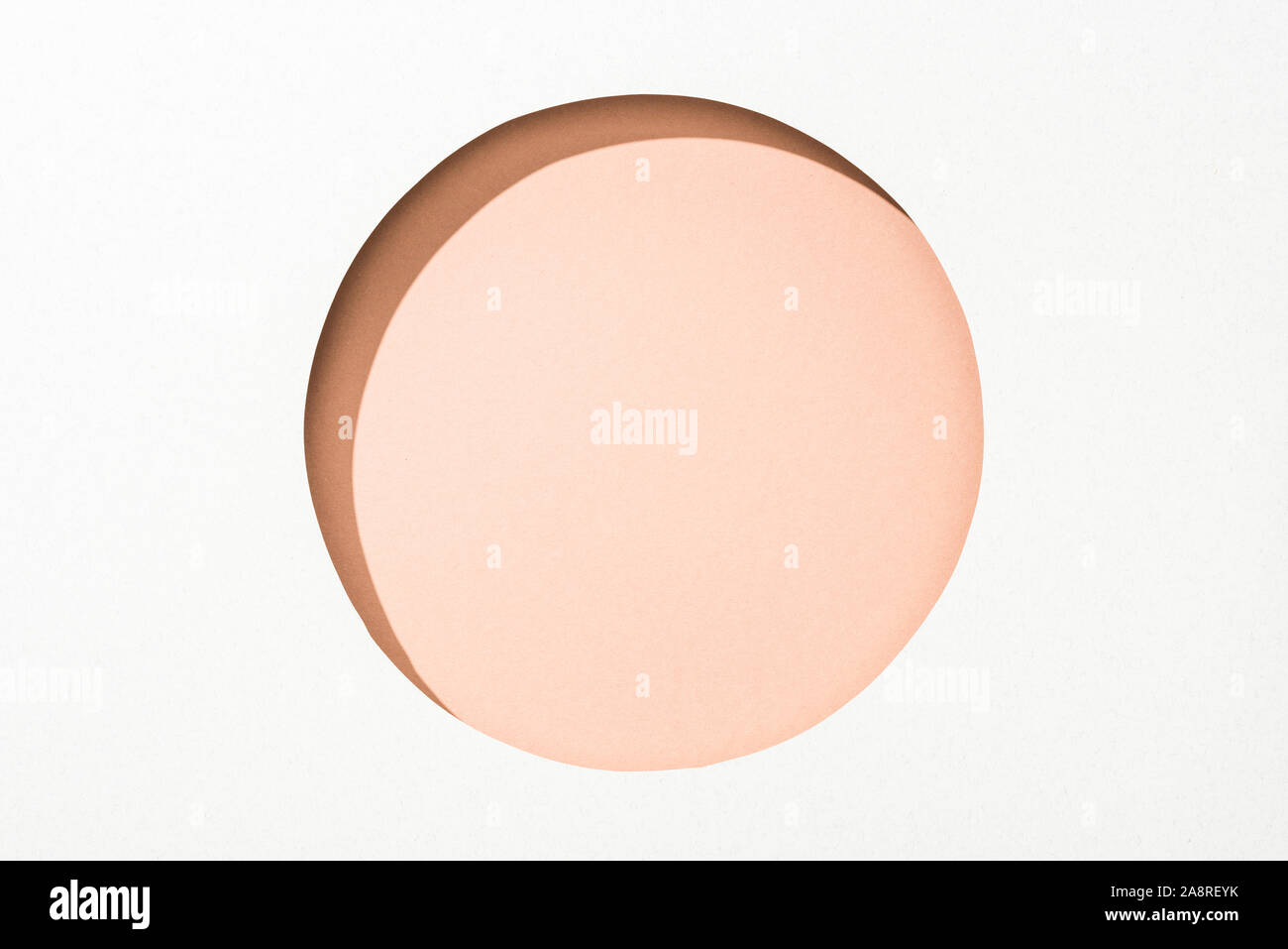 cut out round hole in white paper on beige background Stock Photo - Alamy