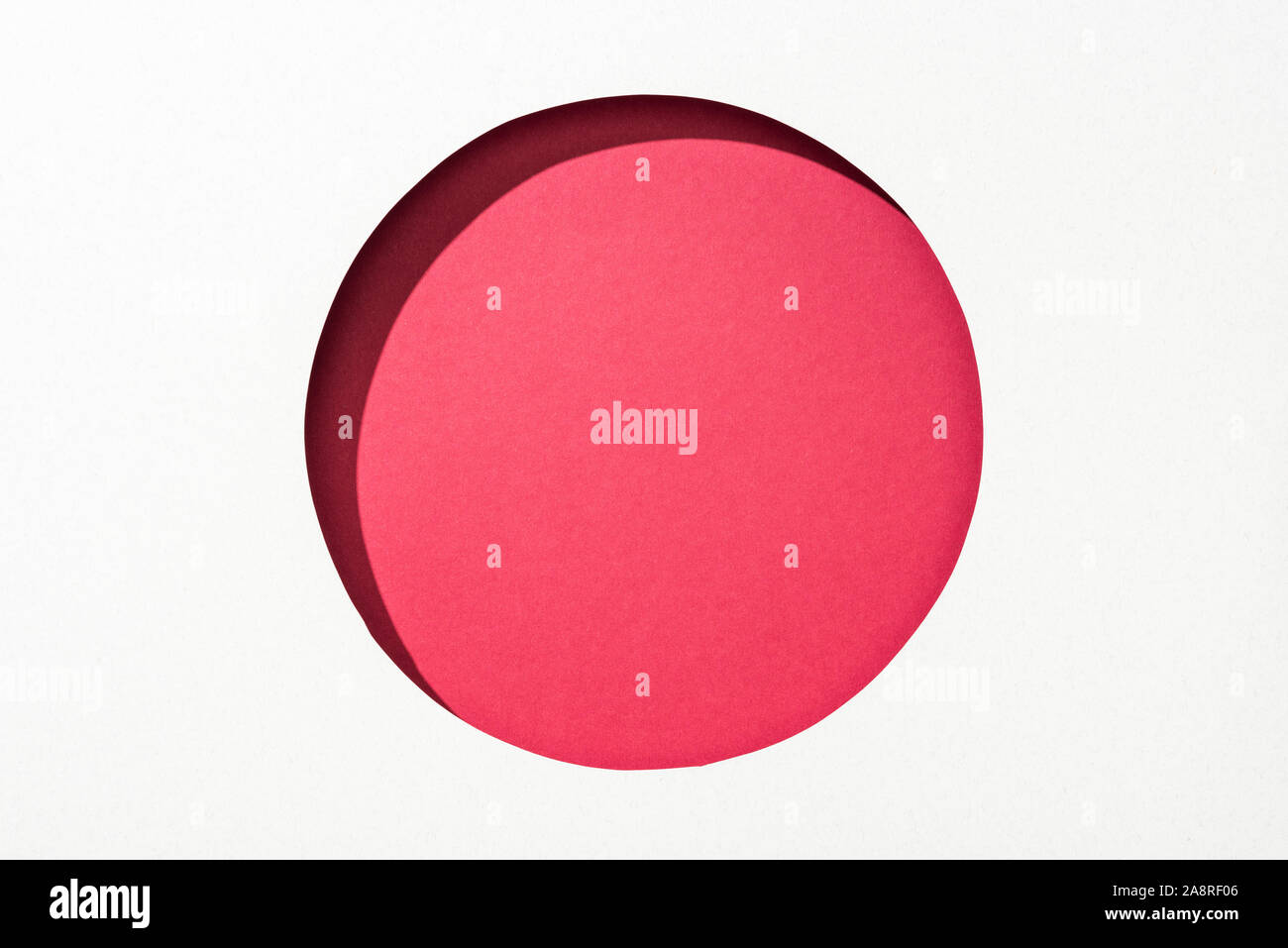 cut out round hole in white paper on red background Stock Photo - Alamy
