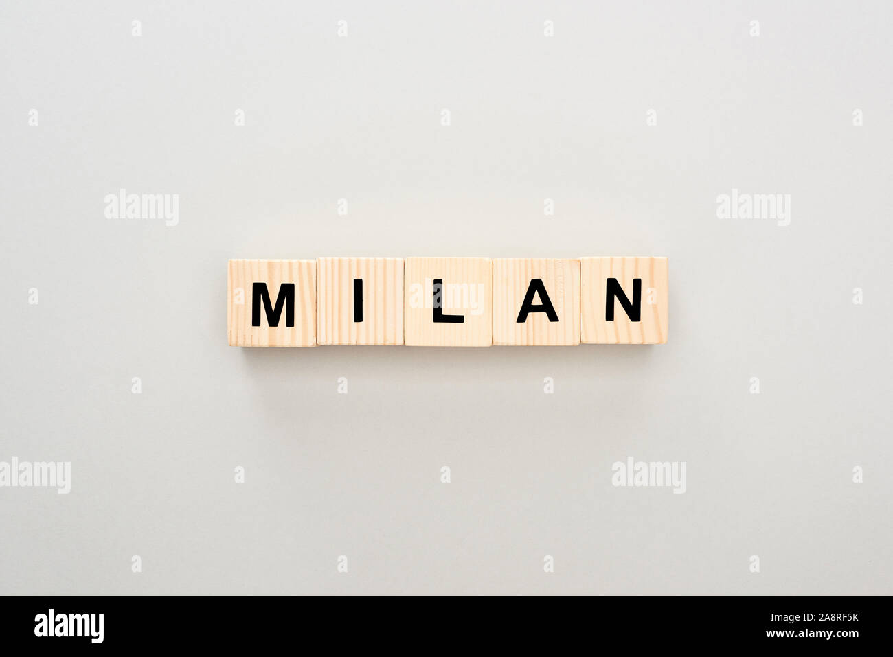 top view of wooden blocks with Milan lettering on white background ...