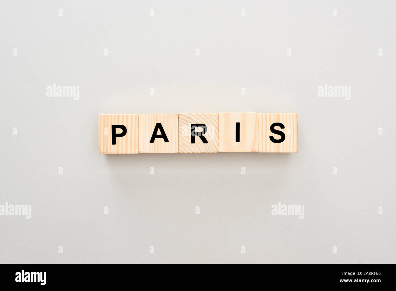 top view of wooden blocks with Paris lettering on white background ...