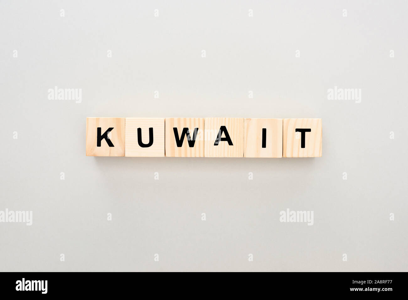top view of wooden blocks with Kuwait lettering on white background ...