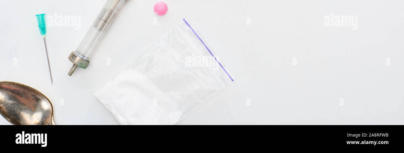 top view of heroin, lsd and syringe with needle and spoon on white ...