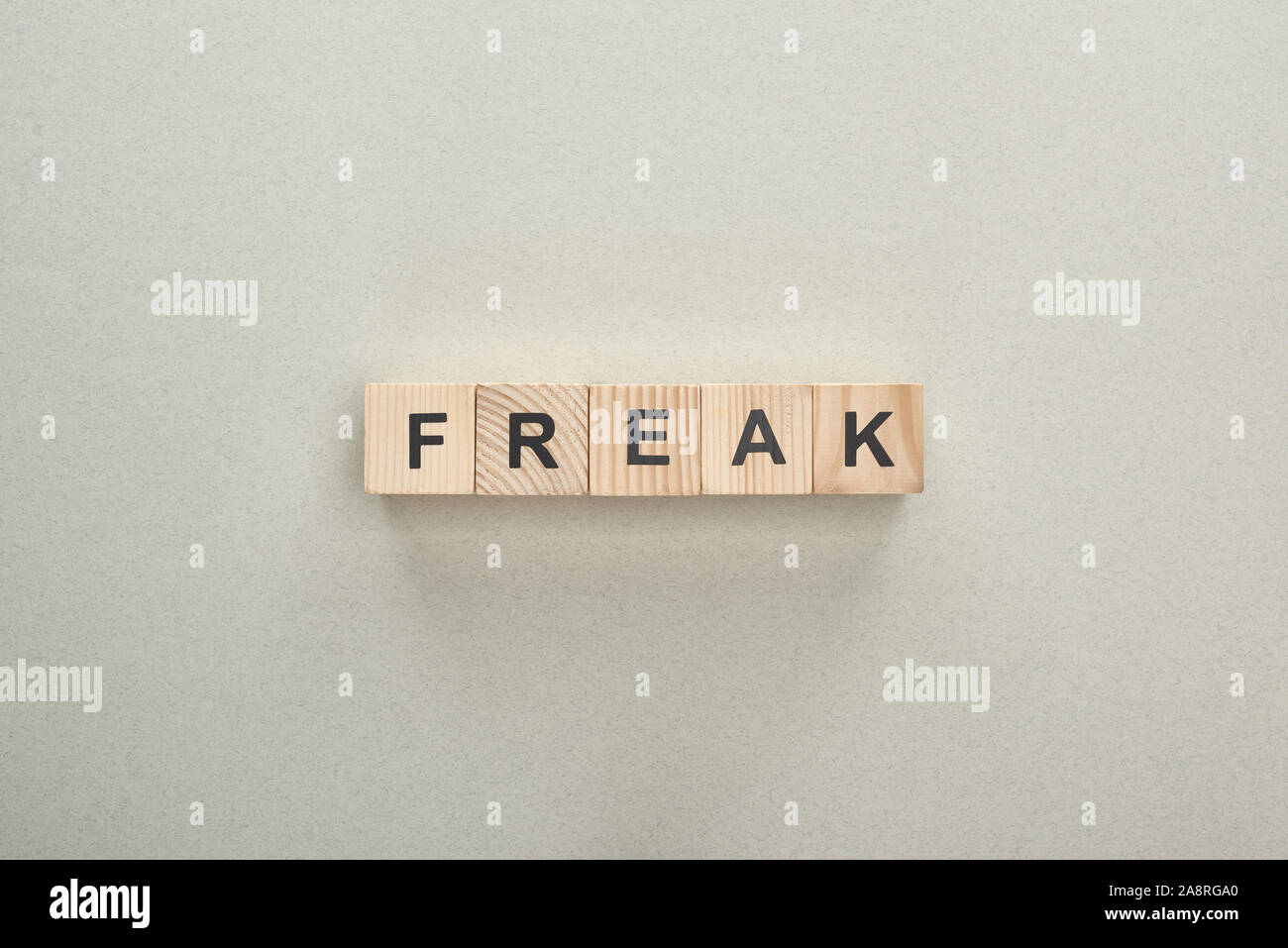 top view of wooden blocks with freak lettering on grey background ...