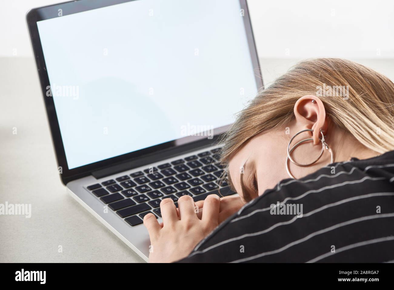 blonde girl sleeping near laptop with blank screen, cyberbullying ...