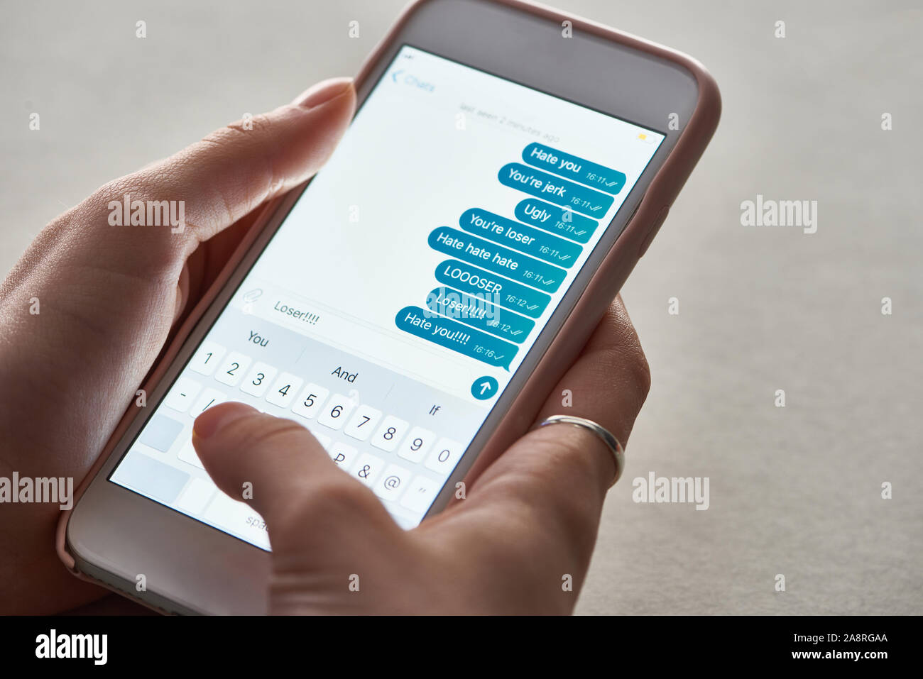 cropped view of abuser sending offensive messages while using ...