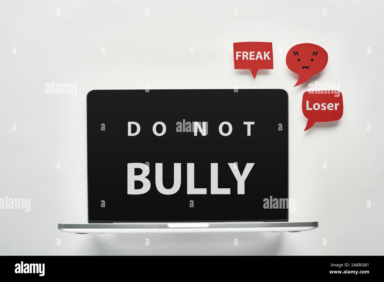 laptop with do not bully lettering on screen on white background near ...