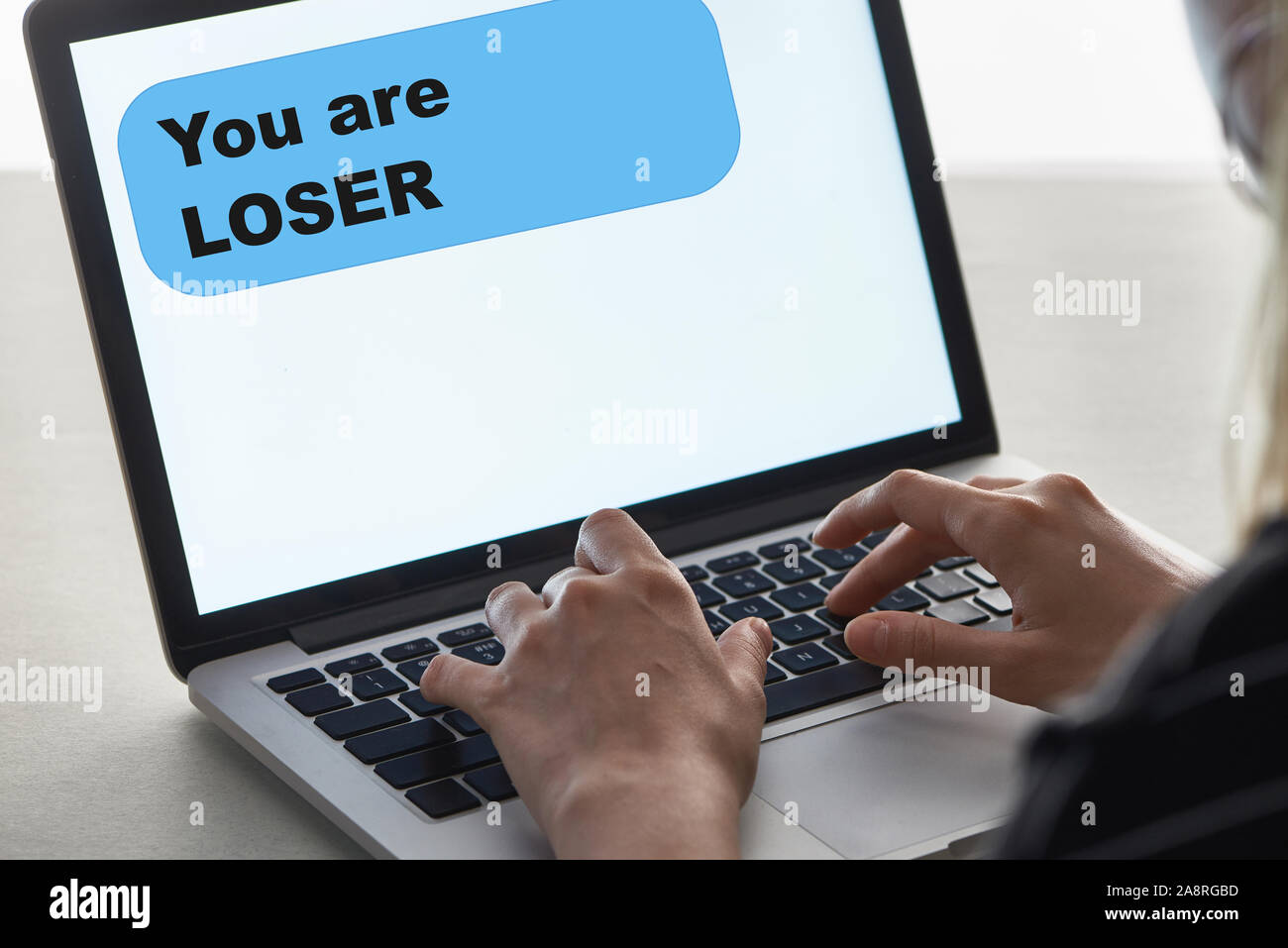cropped view of girl typing on laptop keyboard with you are loser ...