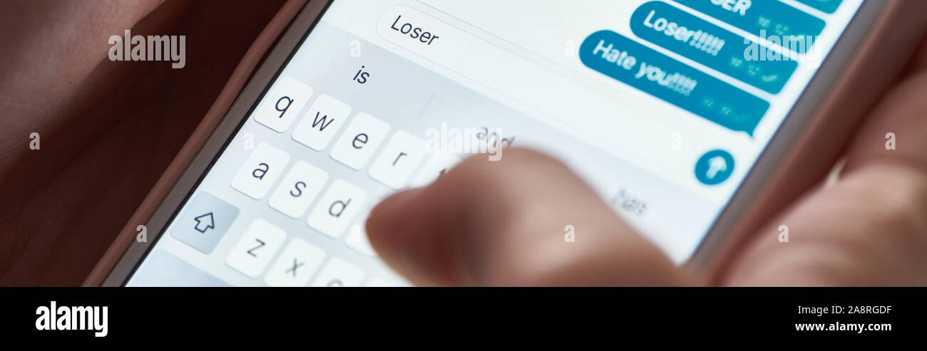 panoramic shot of abuser typing offensive messages while using ...