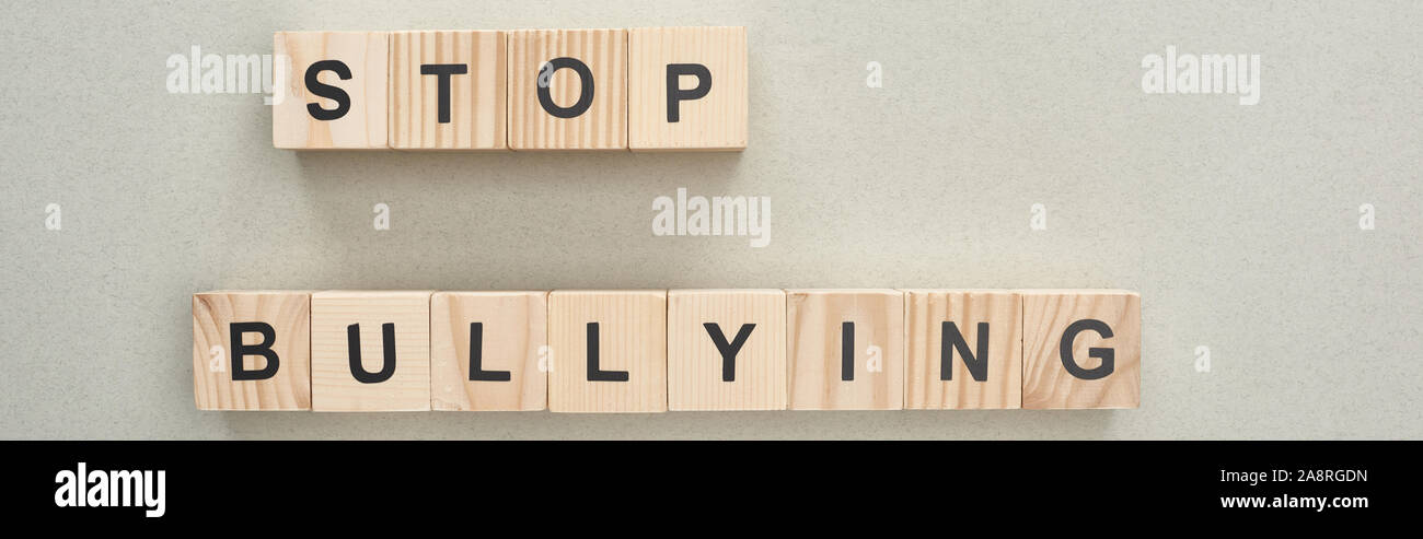 panoramic shot of wooden blocks with stop bullying lettering on grey ...