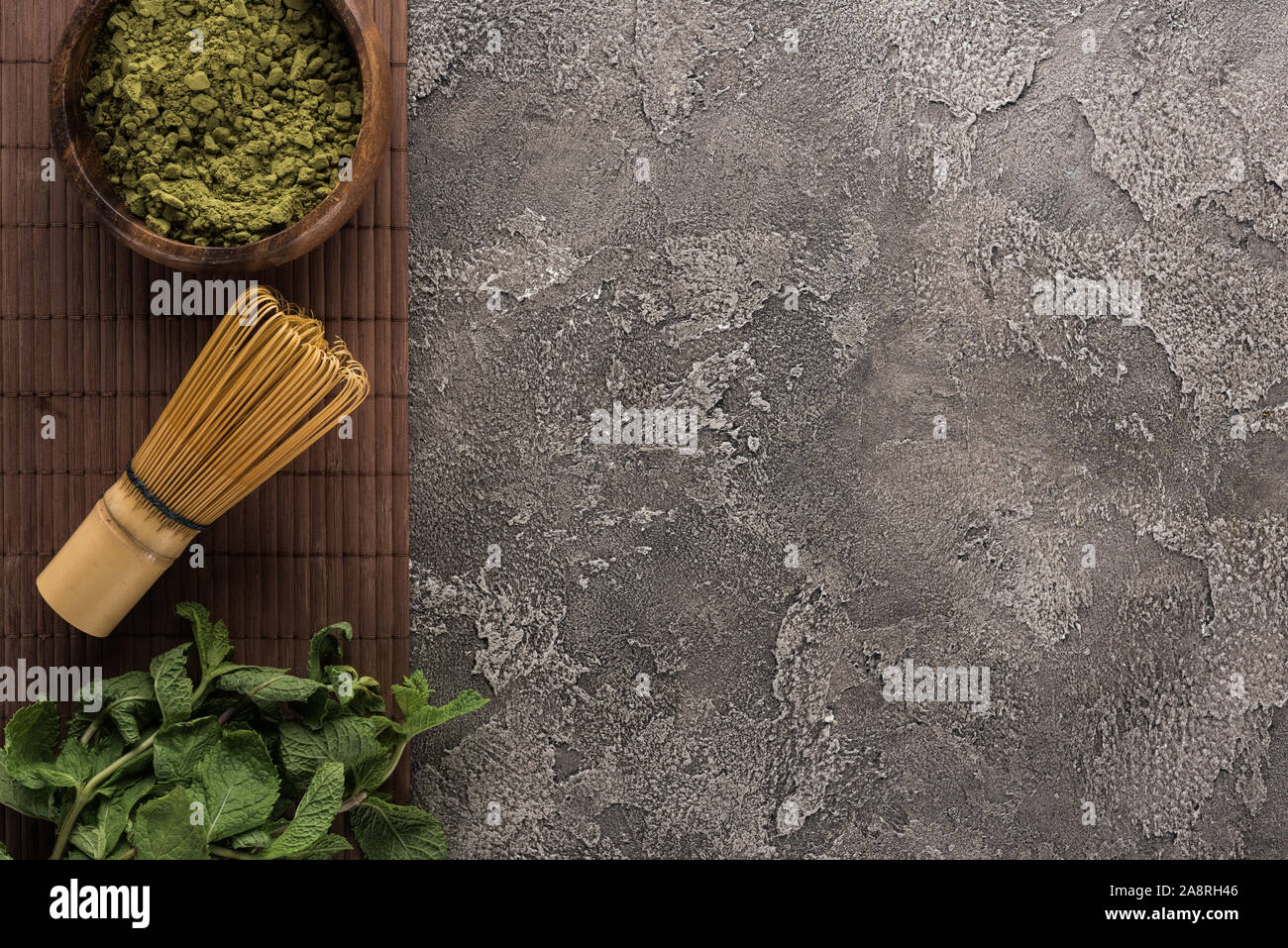 top view of traditional matcha tea on bamboo mat on dark stone table ...