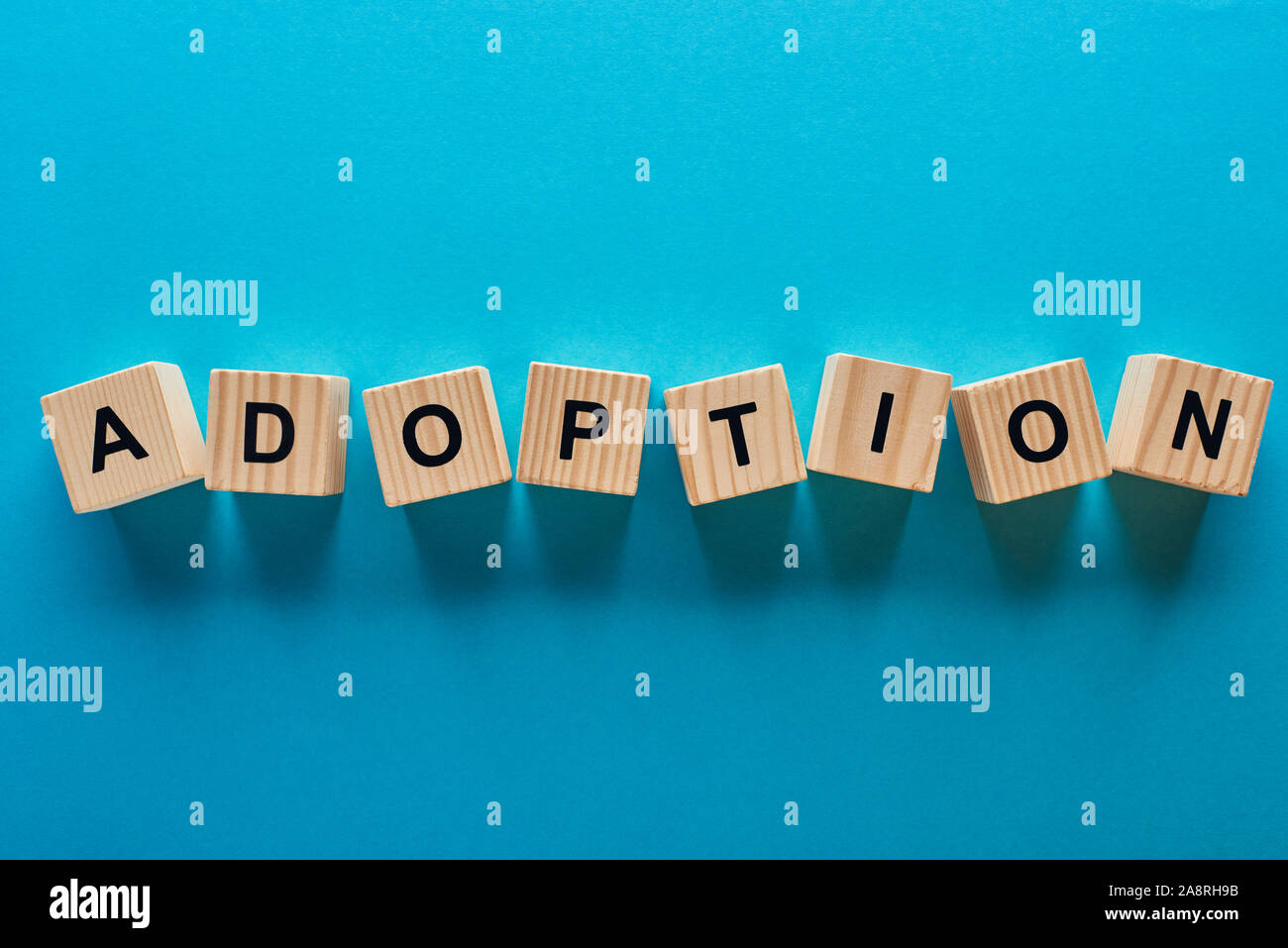 top view of wooden blocks with adoption word on blue background Stock ...