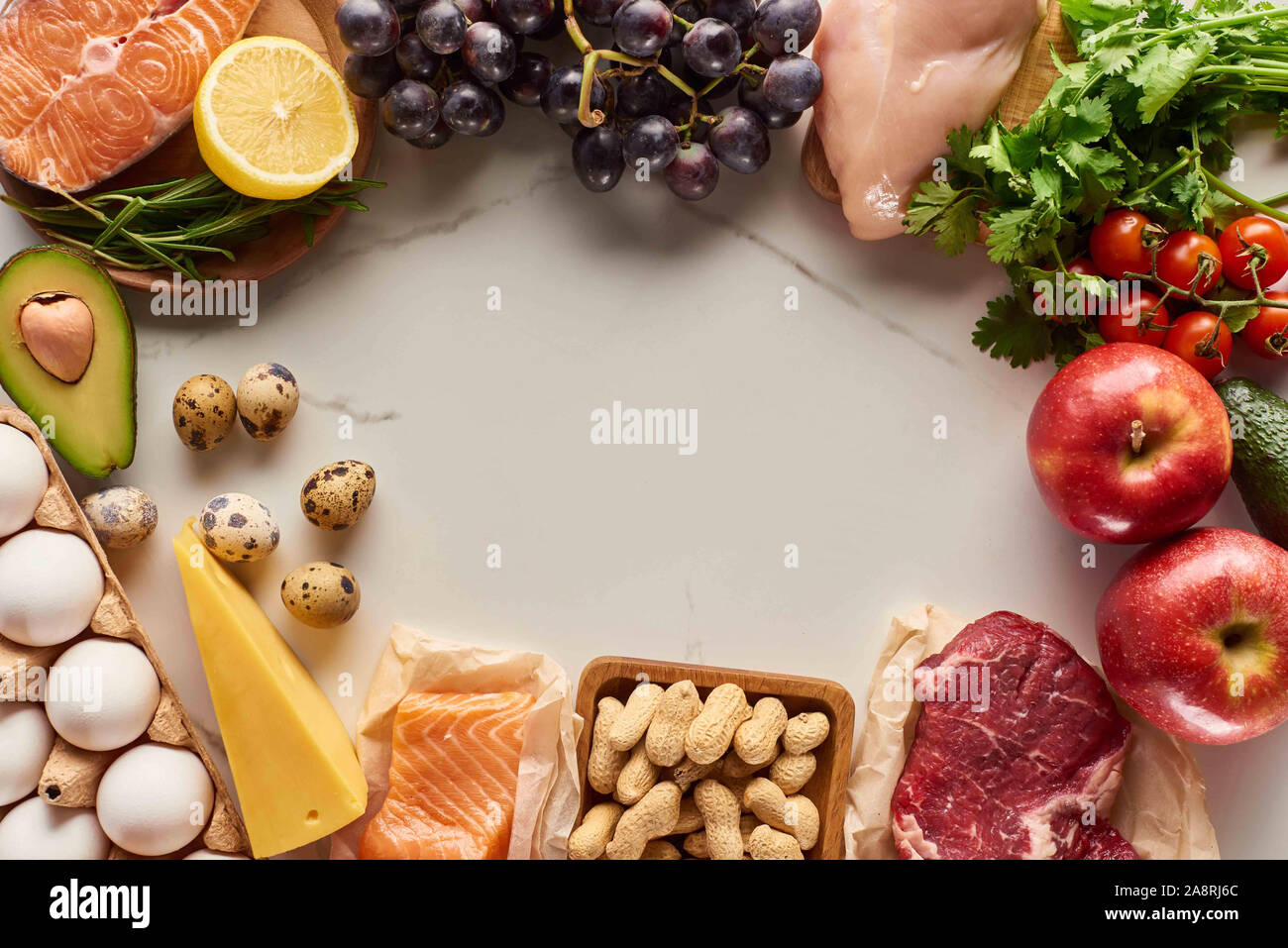 Top view of assorted raw meat, poultry and fish with eggs, avocados ...