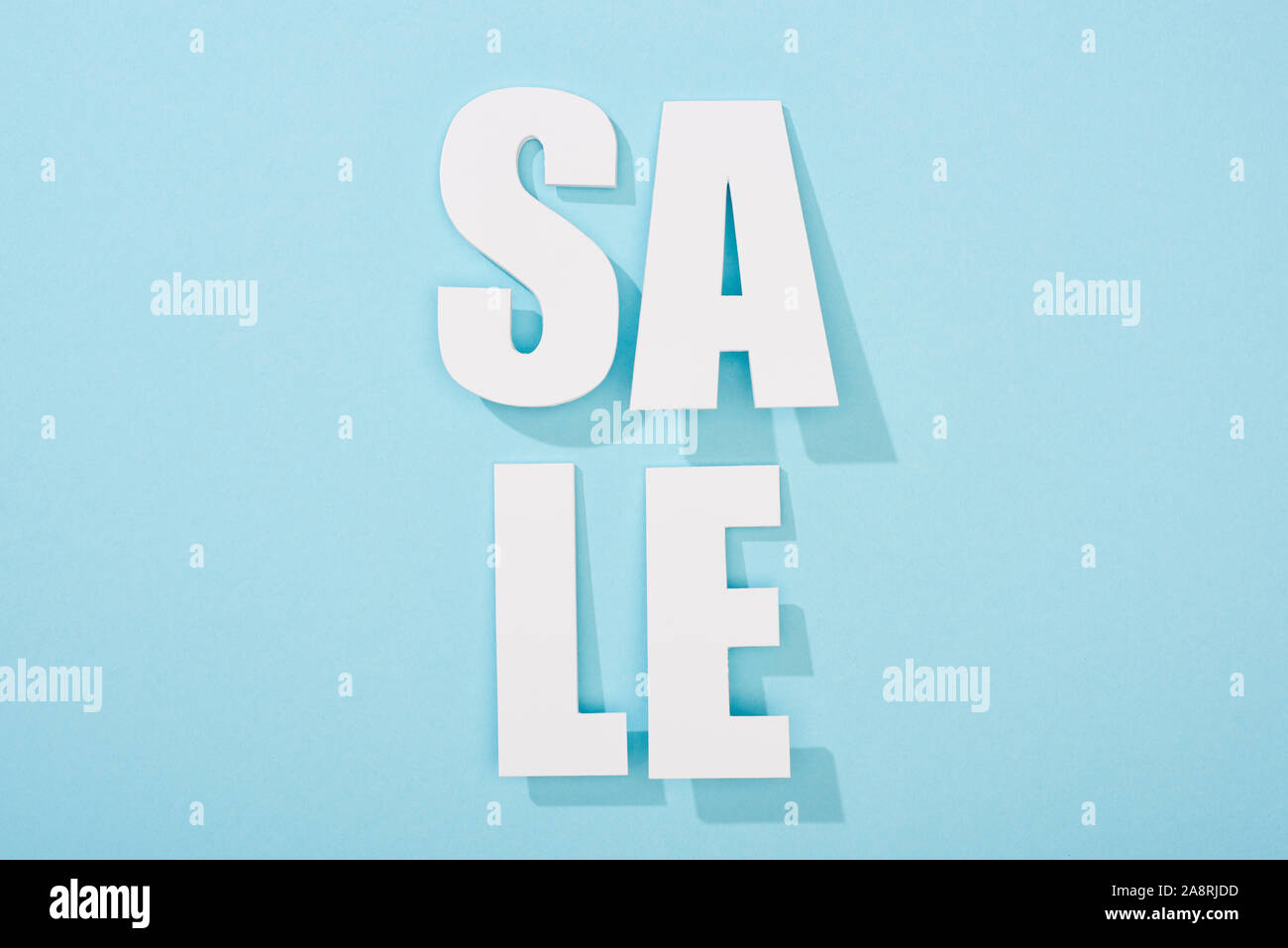 top view of white sale lettering on blue background with copy space ...