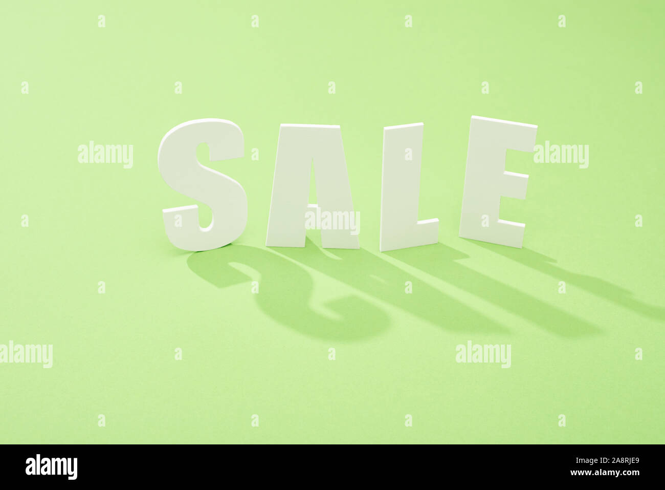 white sale lettering with shadow on green background Stock Photo - Alamy