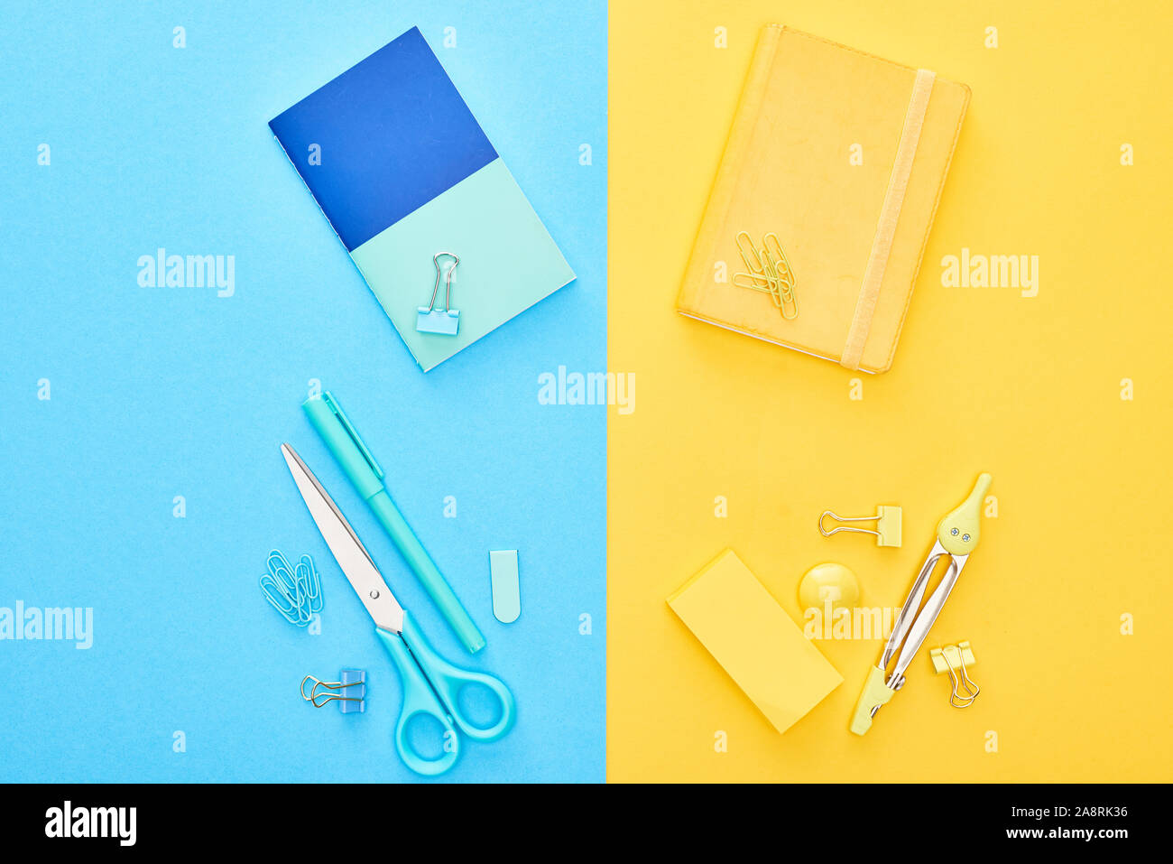 Top view of yellow and blue notepads with different stationery on ...