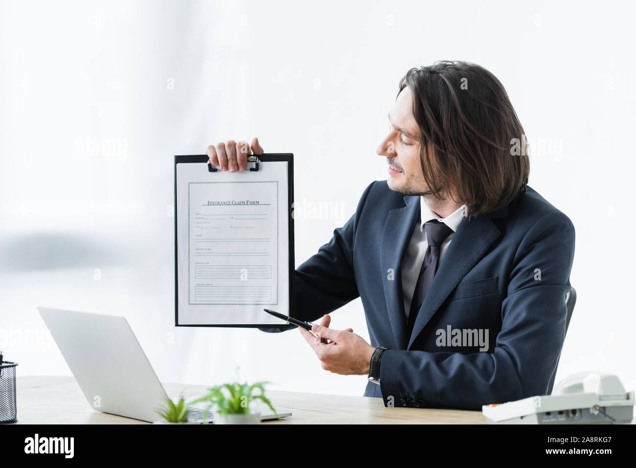 businessmanm pointing with pen on insurance claim form Stock Photo - Alamy