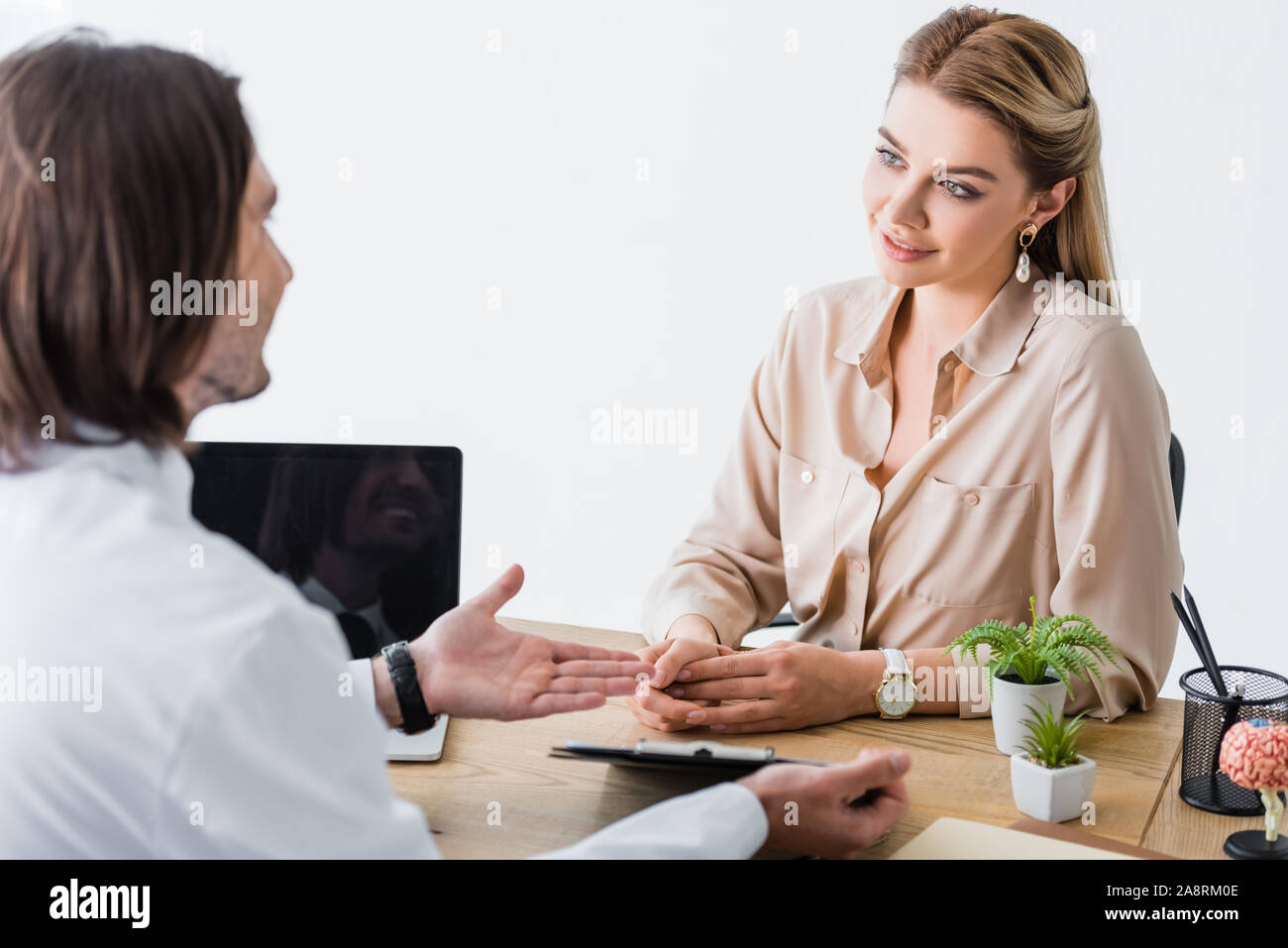 doctor talking with patient, holding document in hands and sitting ...