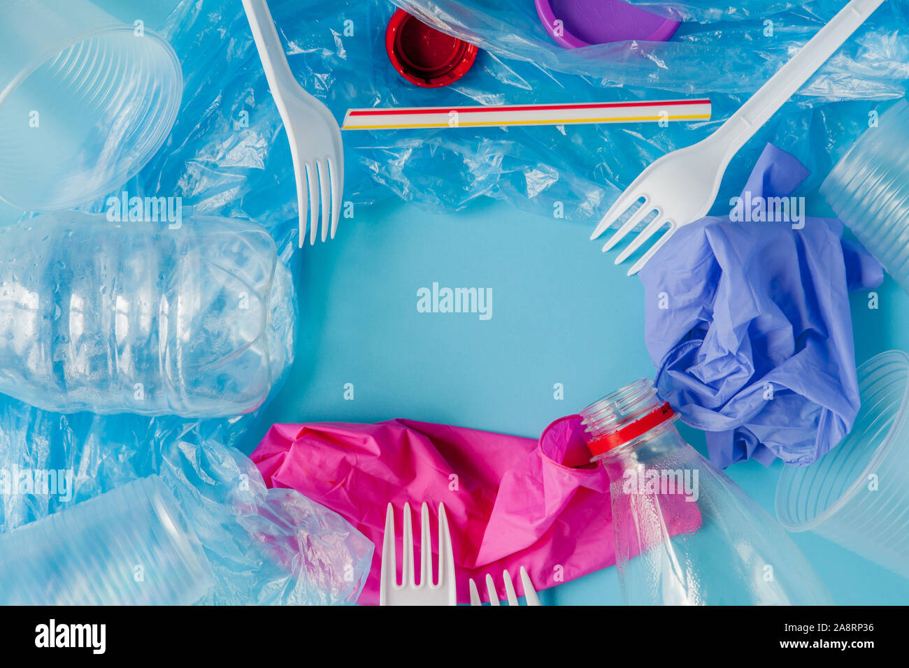 Top view of various kinds of disposable plastic waste on blue ...