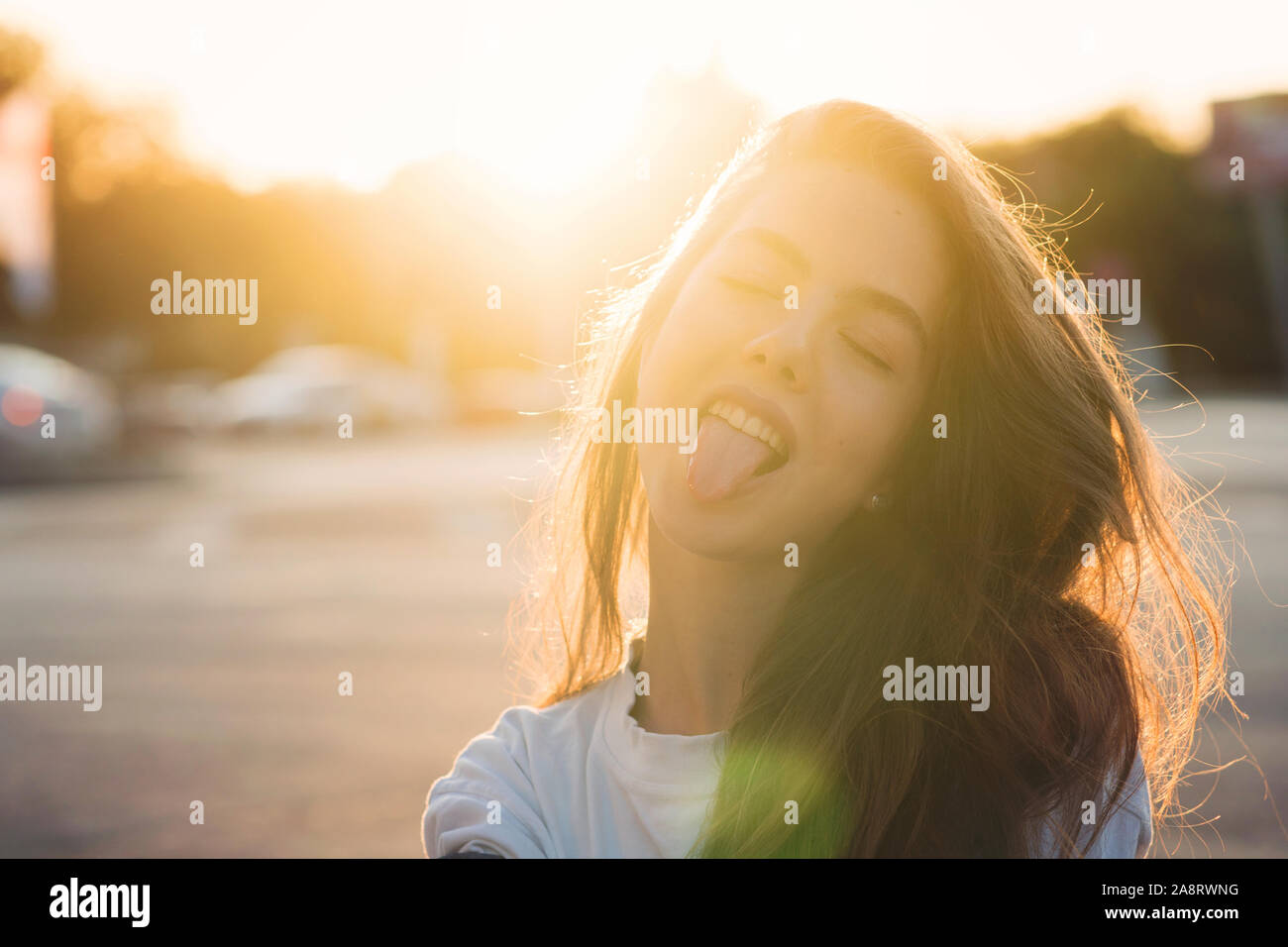 Back light portrait of a happy single teen girl breathing fresh air in ...