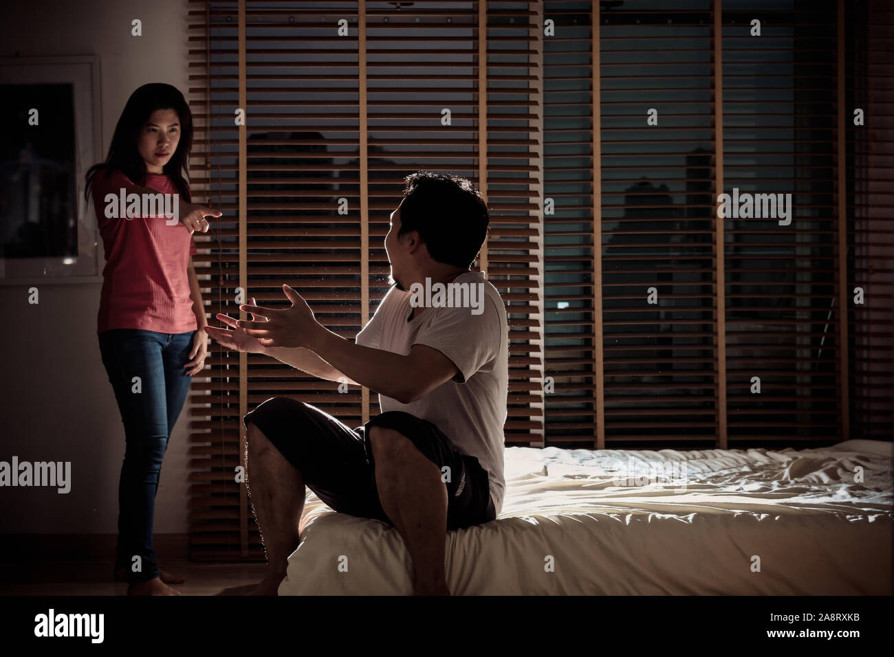 depressed Couple Husband and wife are quarreling on the bed in the dark ...