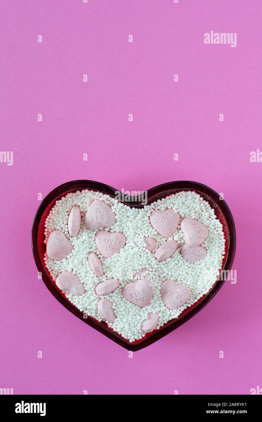 Valentine candy hearts and sprinkles in a heart-shaped dish Stock Photo ...