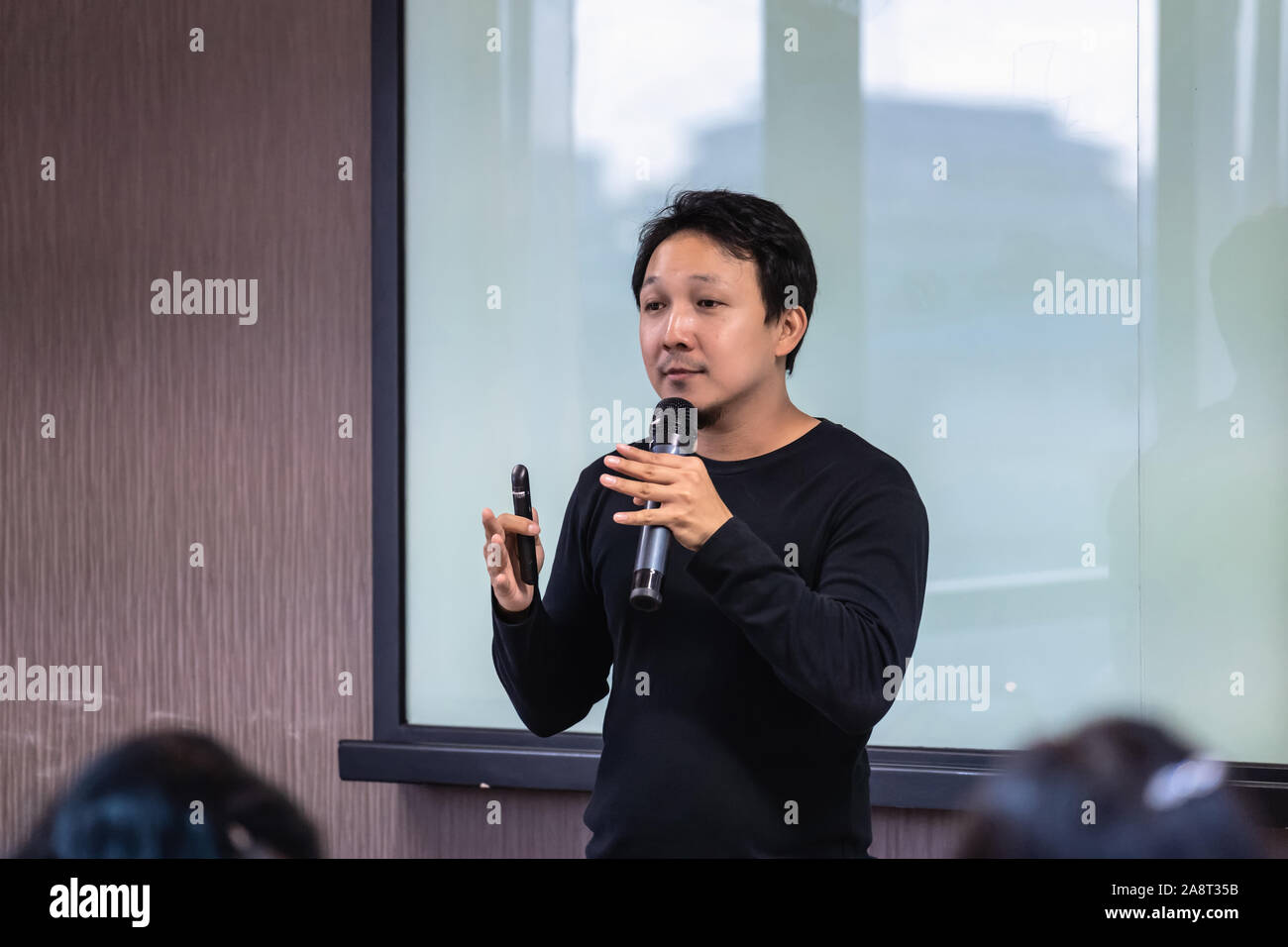 Asian Speaker or lecture with casual suit on the stage in front of the ...
