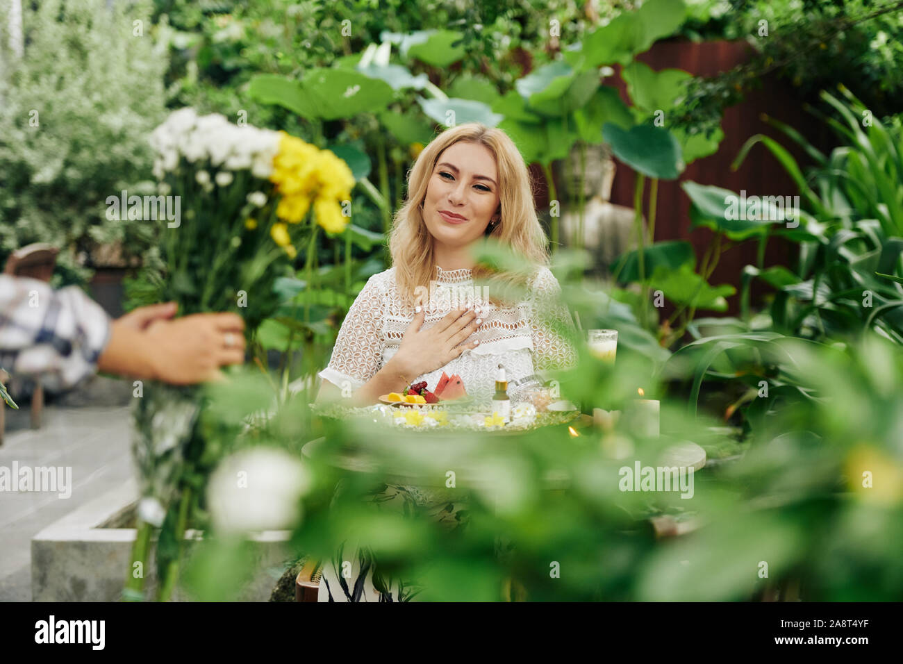 Pretty young woman happy to accept bouquet of beautiful flowers from ...