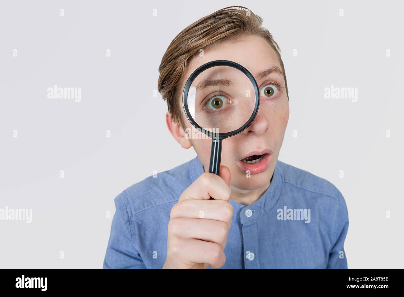Curious Teenager with Magnifying Glass Isolated on the White Background ...