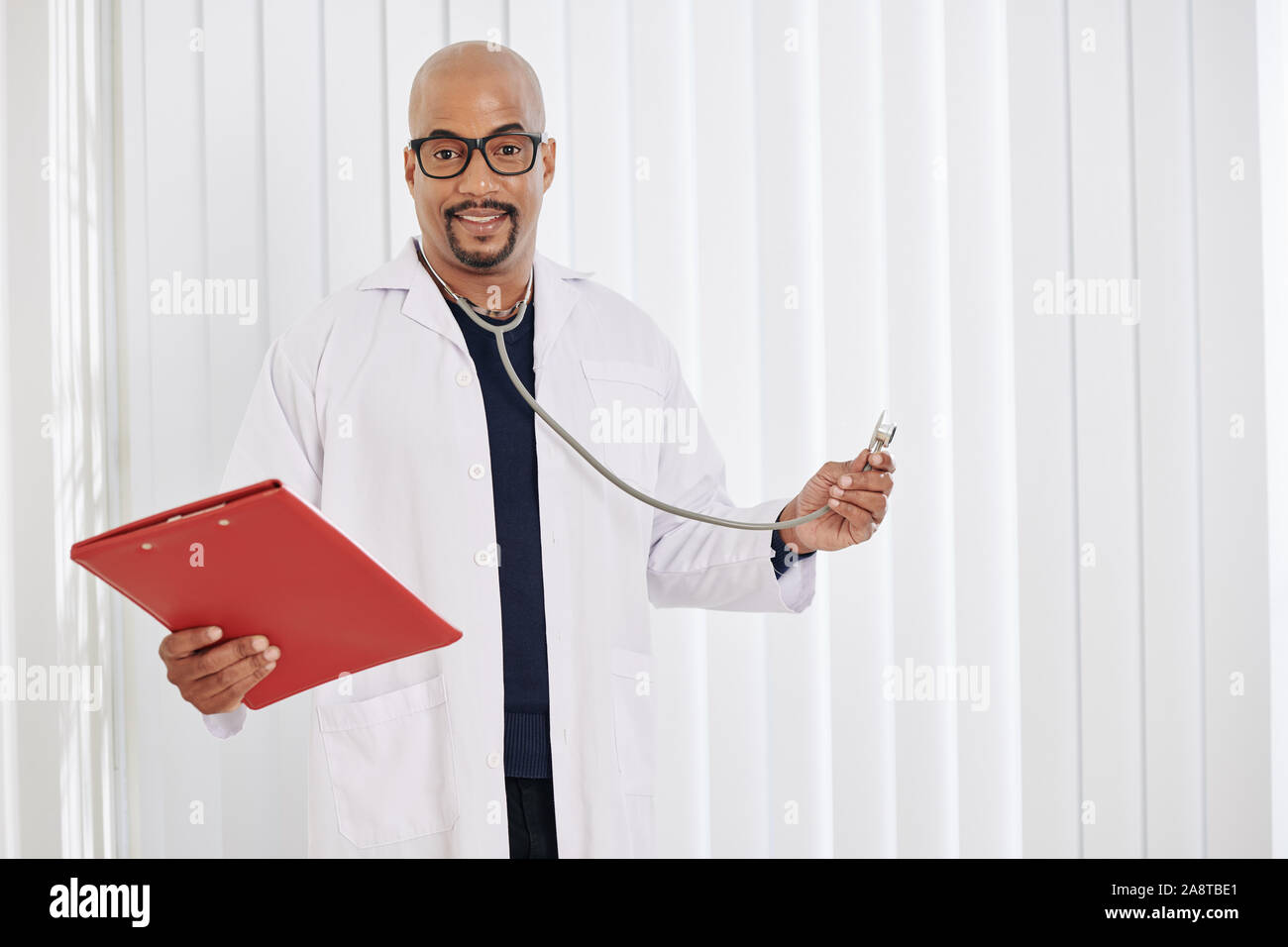 Positive smiling general practitioner with medical history and ...