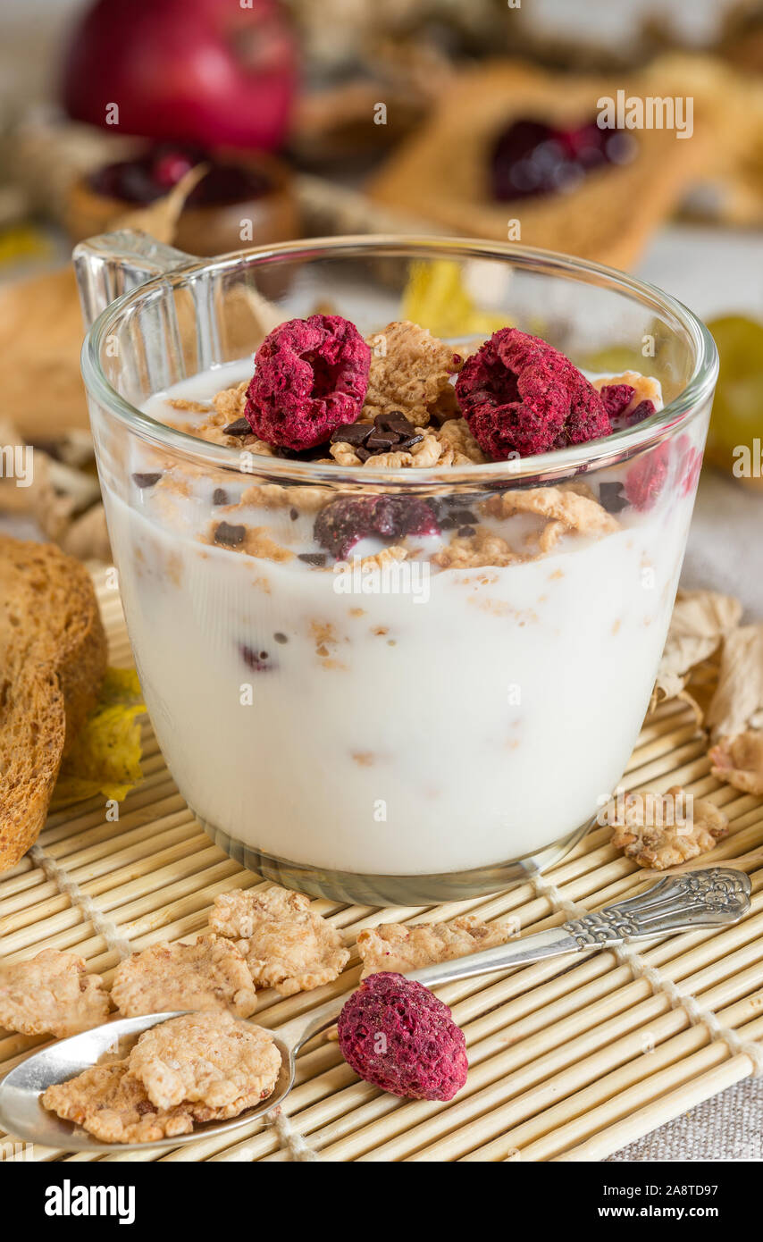 autumnal food background with milk, cereal, rusks and wildberries jam ...
