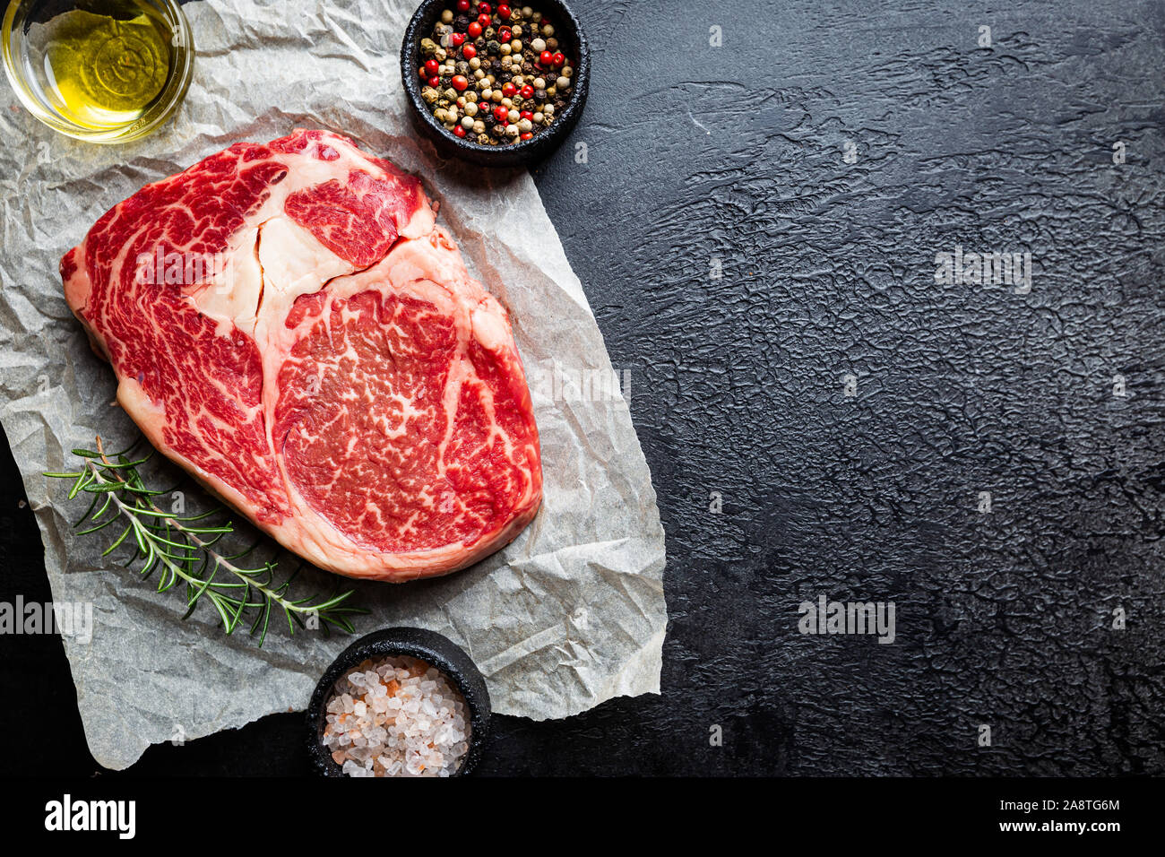 Raw fresh meat Ribeye Steak and seasonings on dark background, top view ...