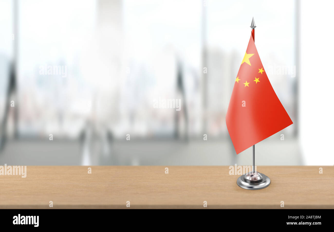 Chinese flag is standing on a metal pole is at wooden office table ...