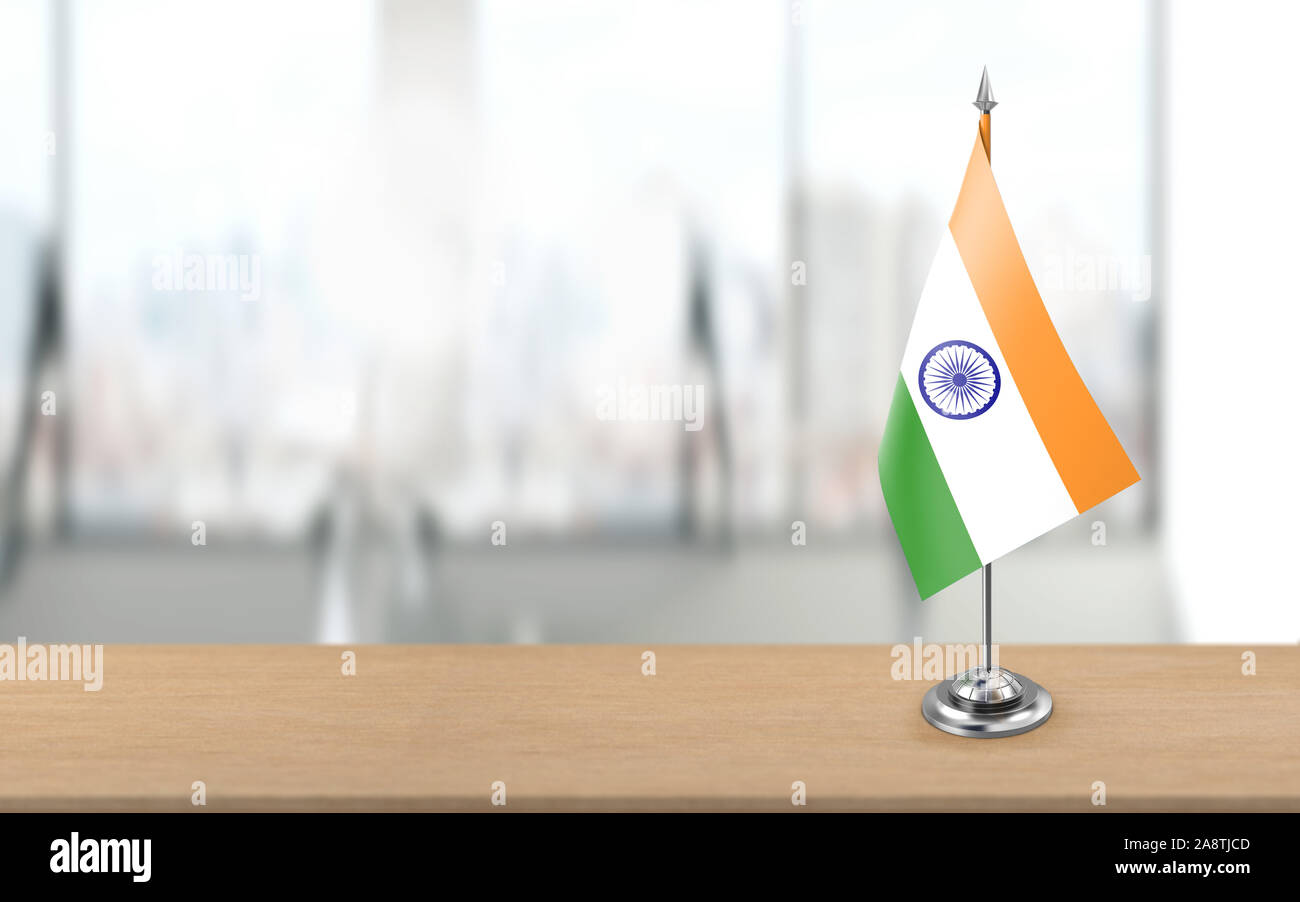 Indian flag is standing on a metal pole is at wooden office table. High ...
