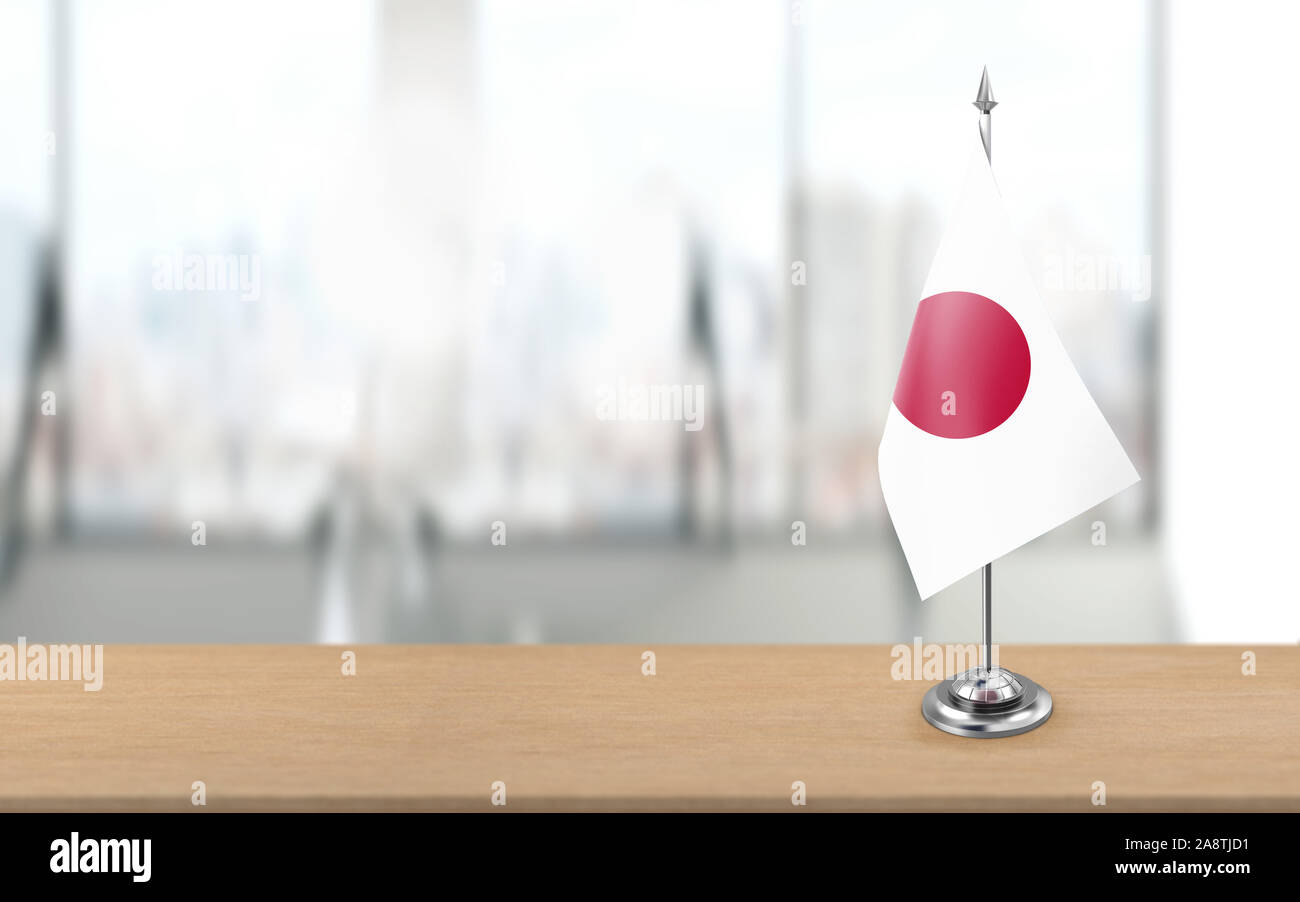 Japanese flag is standing on a metal pole is at wooden office table ...